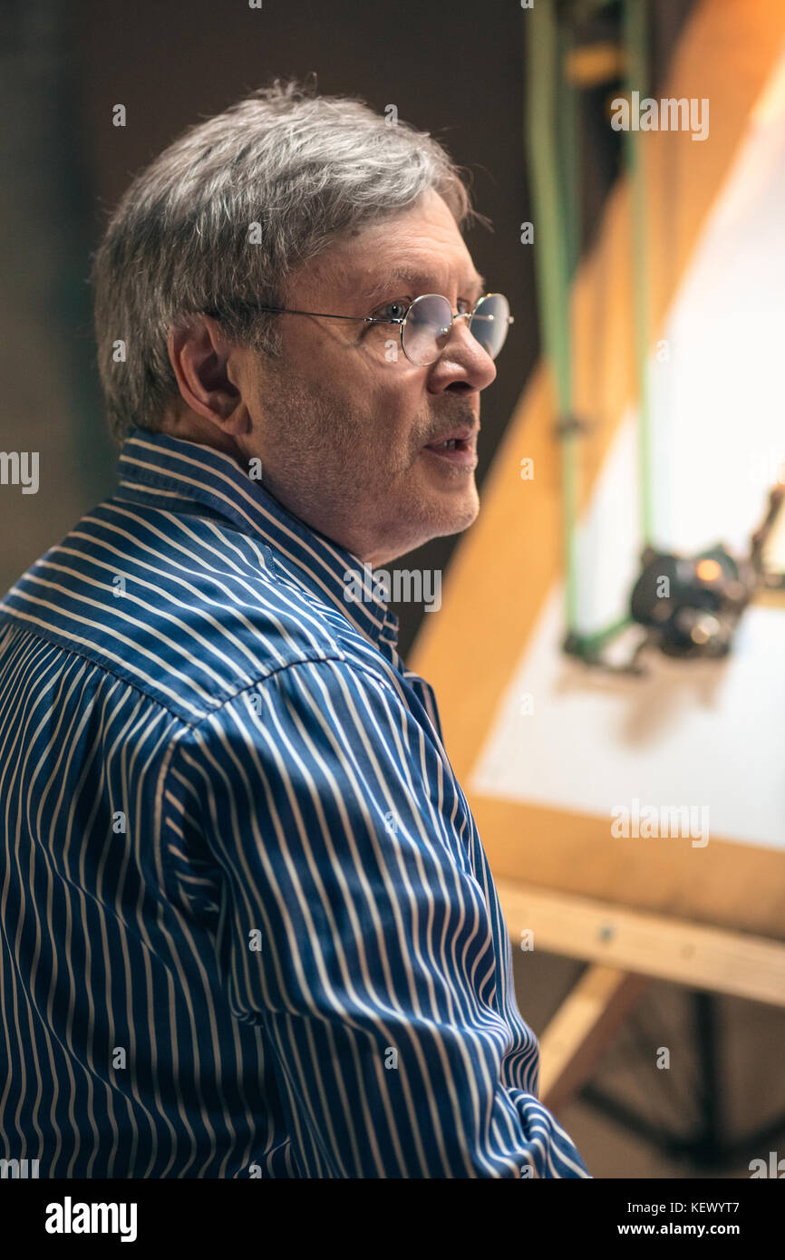 The mature creative engineer working with project on drawing board ...