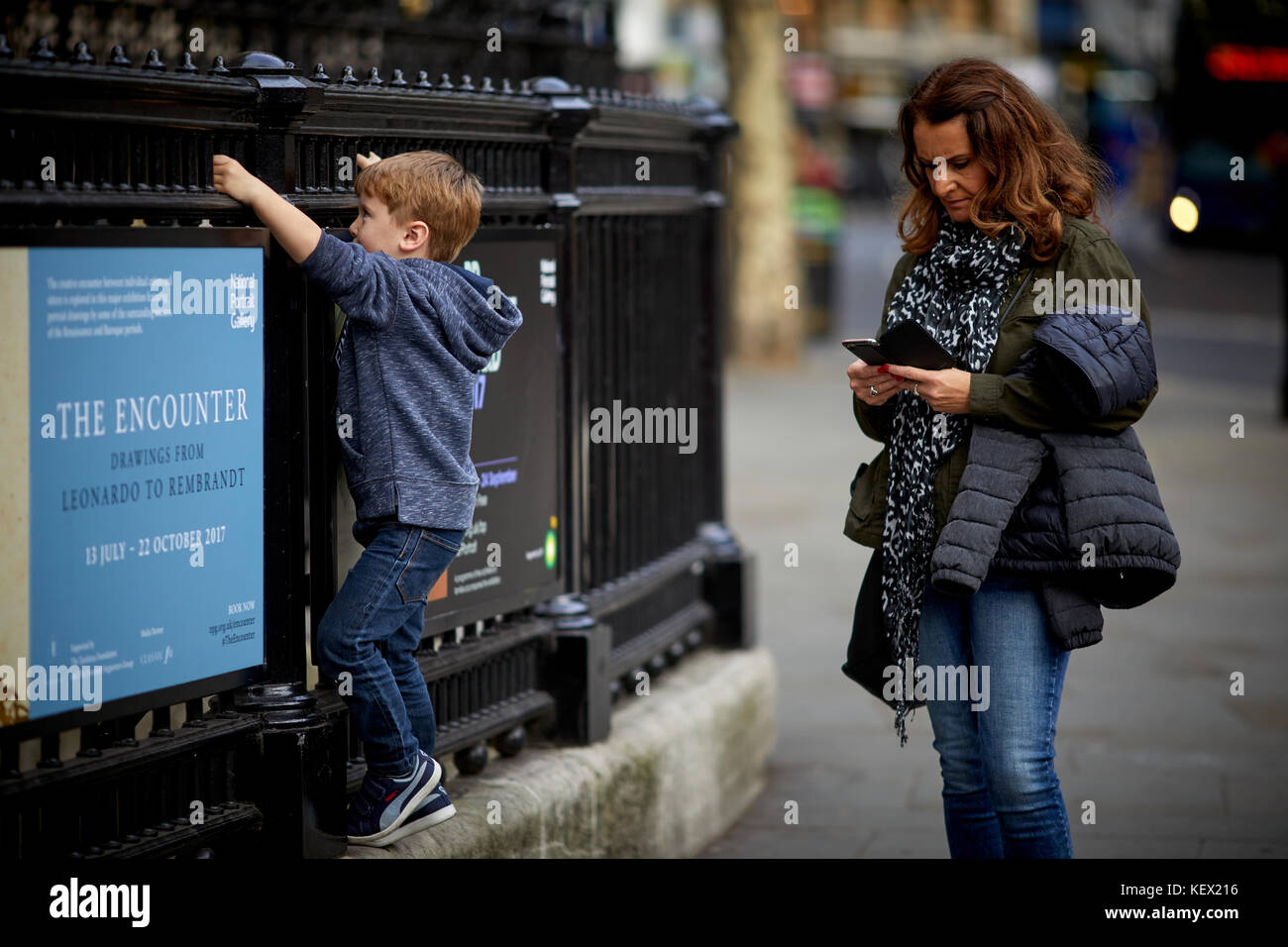 Mum texting as child plays on railings National Portrait Gallery in ...