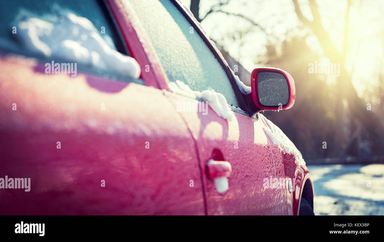 Frozen red car parked outside, with focus on rear view mirror, winter ...