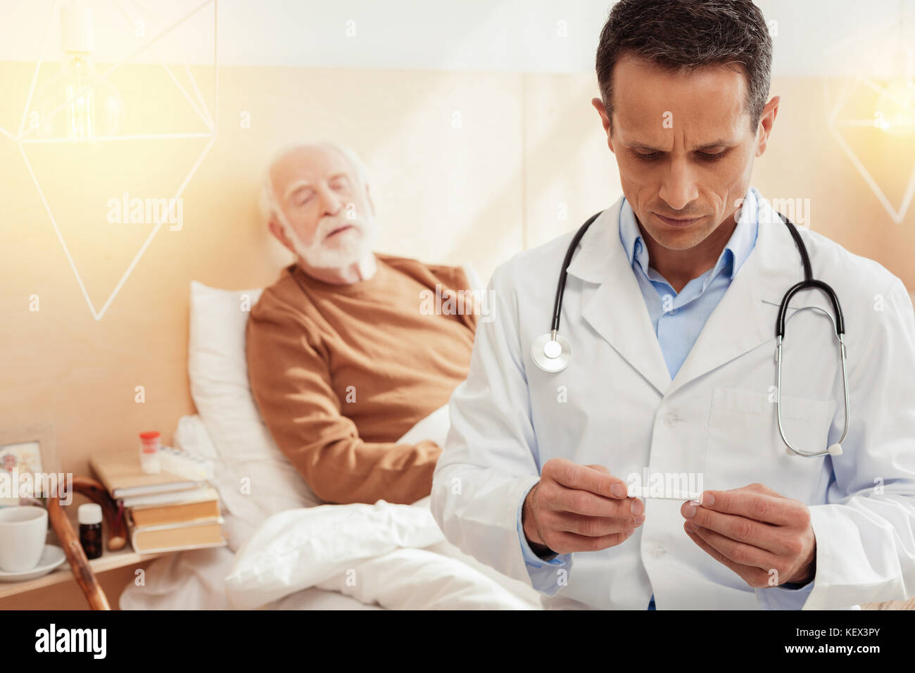 Concentrated doctor checking temperature of his patient Stock Photo - Alamy