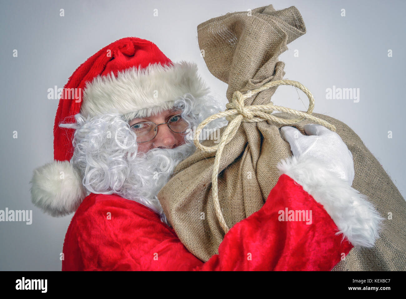 Santa Claus holding big sack full of christmas presents Stock Photo - Alamy