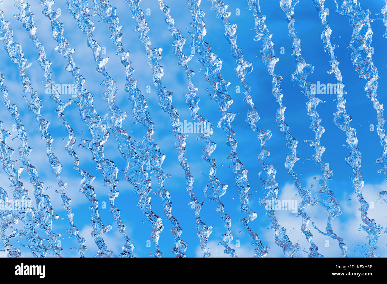 Abstract detail of water falling from a fountain against a blue sky ...