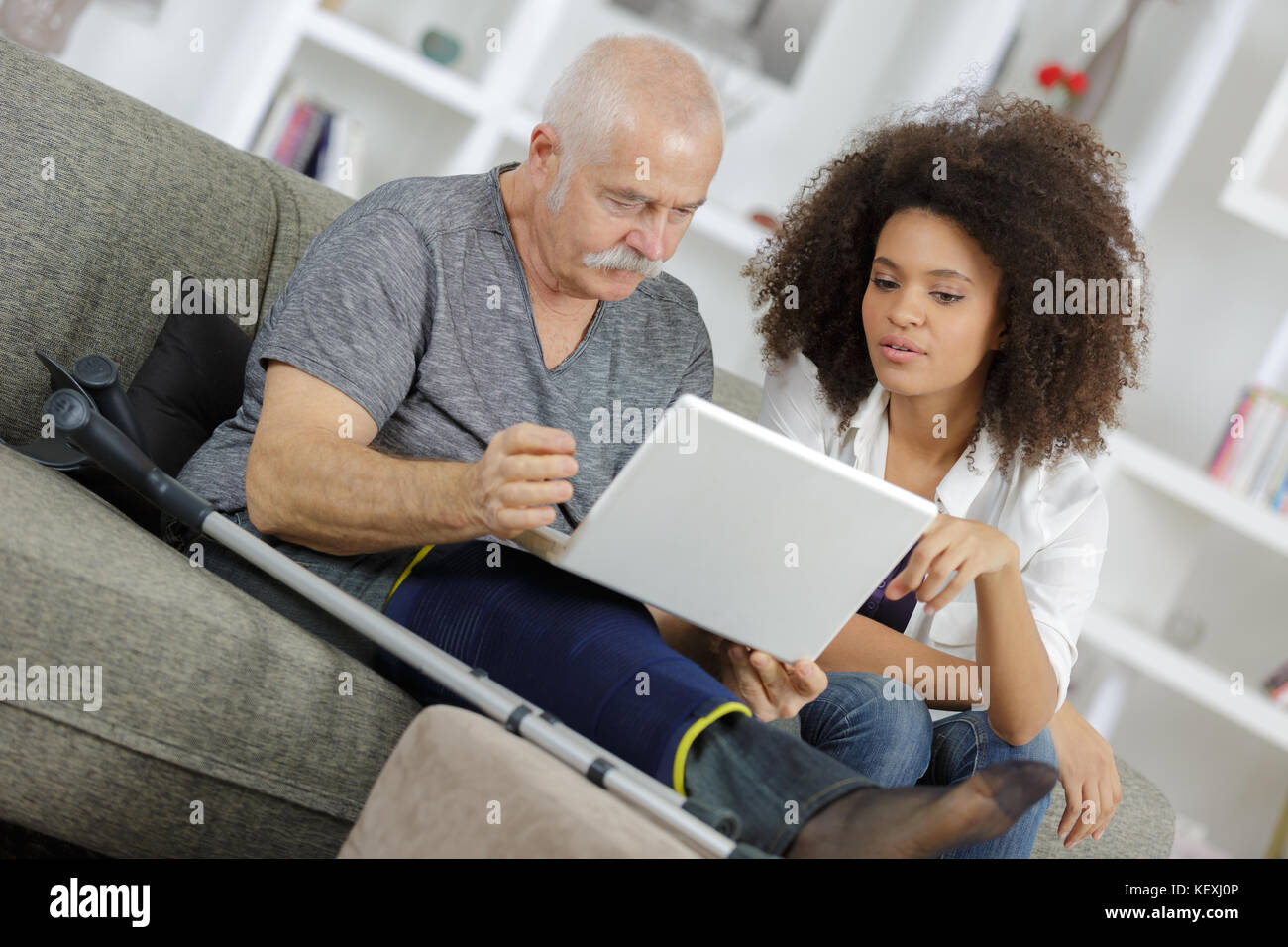 young woman helping senior man with a laptop computer Stock Photo - Alamy