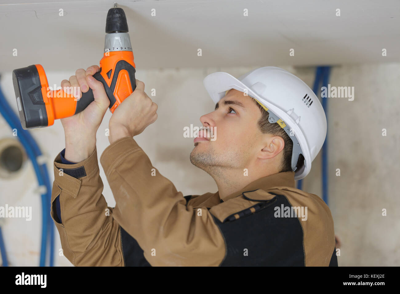 construction builder drilling ceiling Stock Photo - Alamy