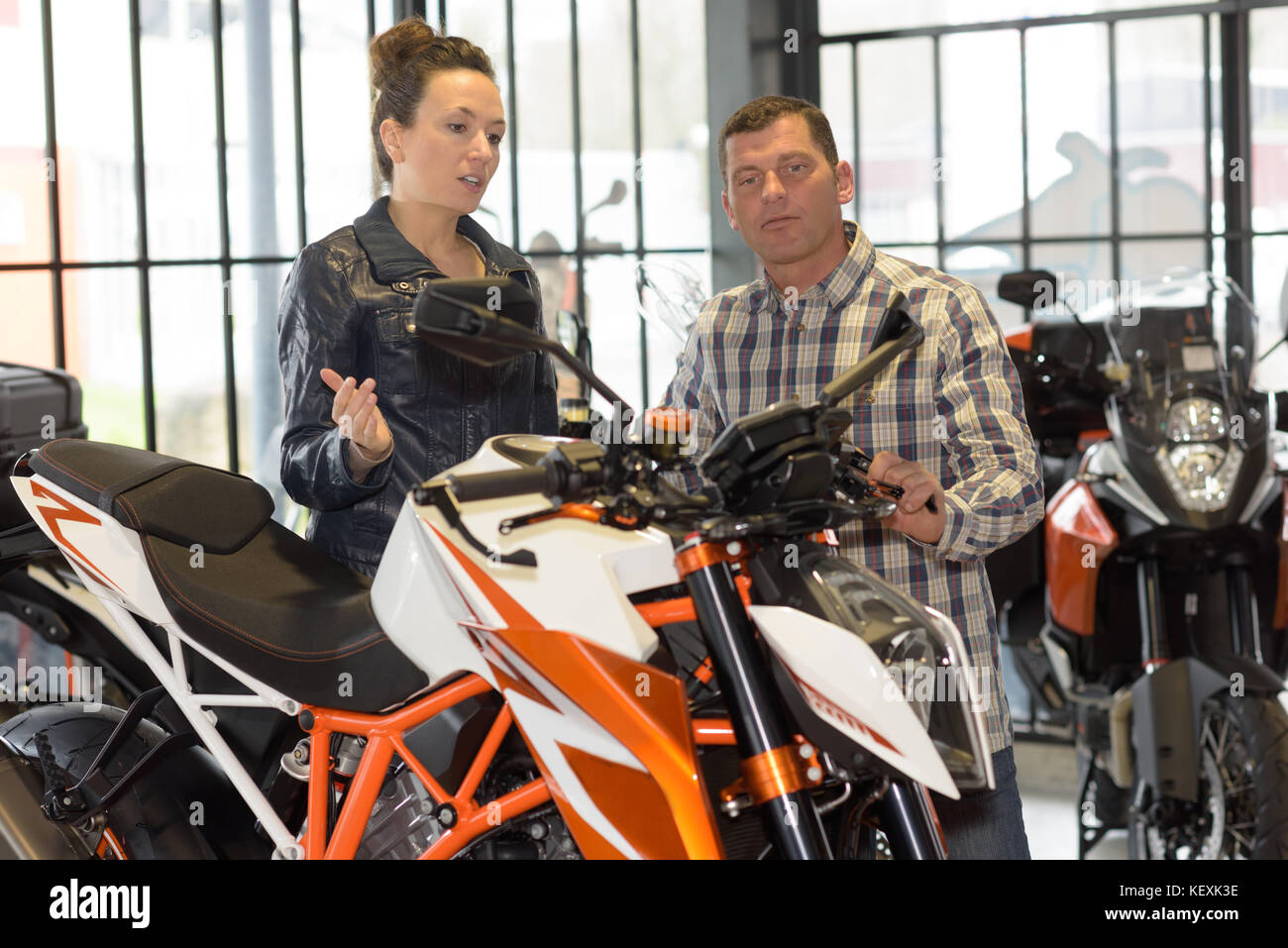 cheerful couple buying a motorcycle Stock Photo - Alamy