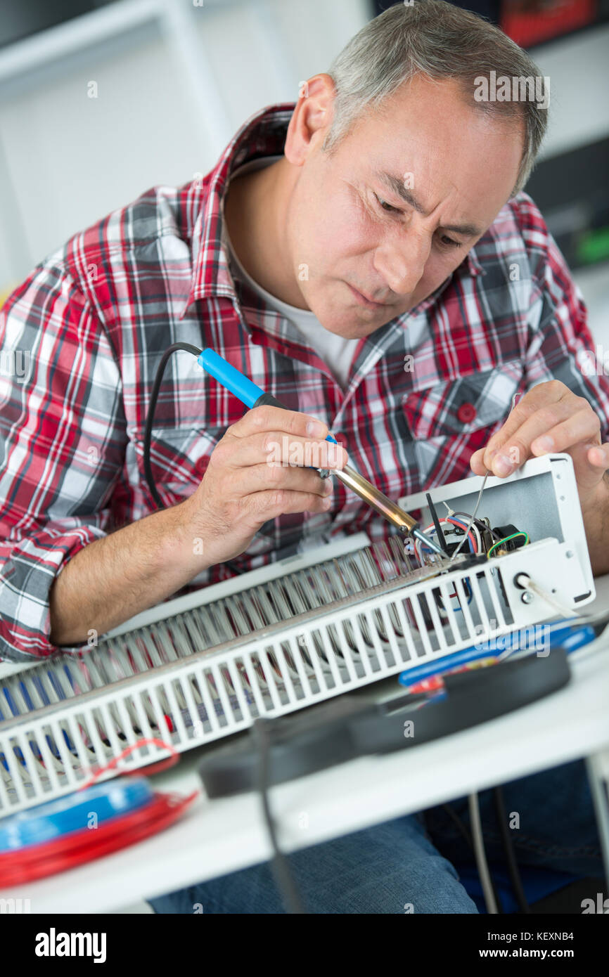 mature man repairing radiator Stock Photo - Alamy