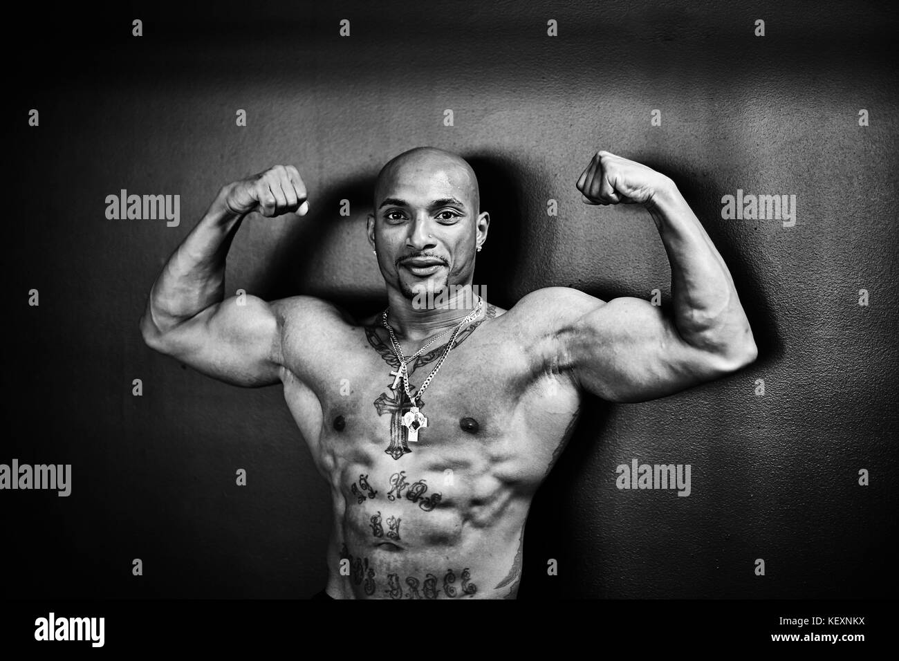 Black and white studio portrait of shirtless bodybuilder flexing ...