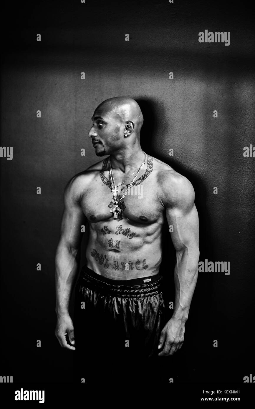Black and white studio portrait of shirtless bodybuilder standing and ...