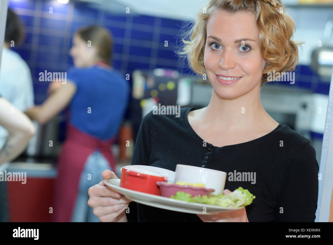 happy young waitress serving dishes in a restaurant Stock Photo - Alamy