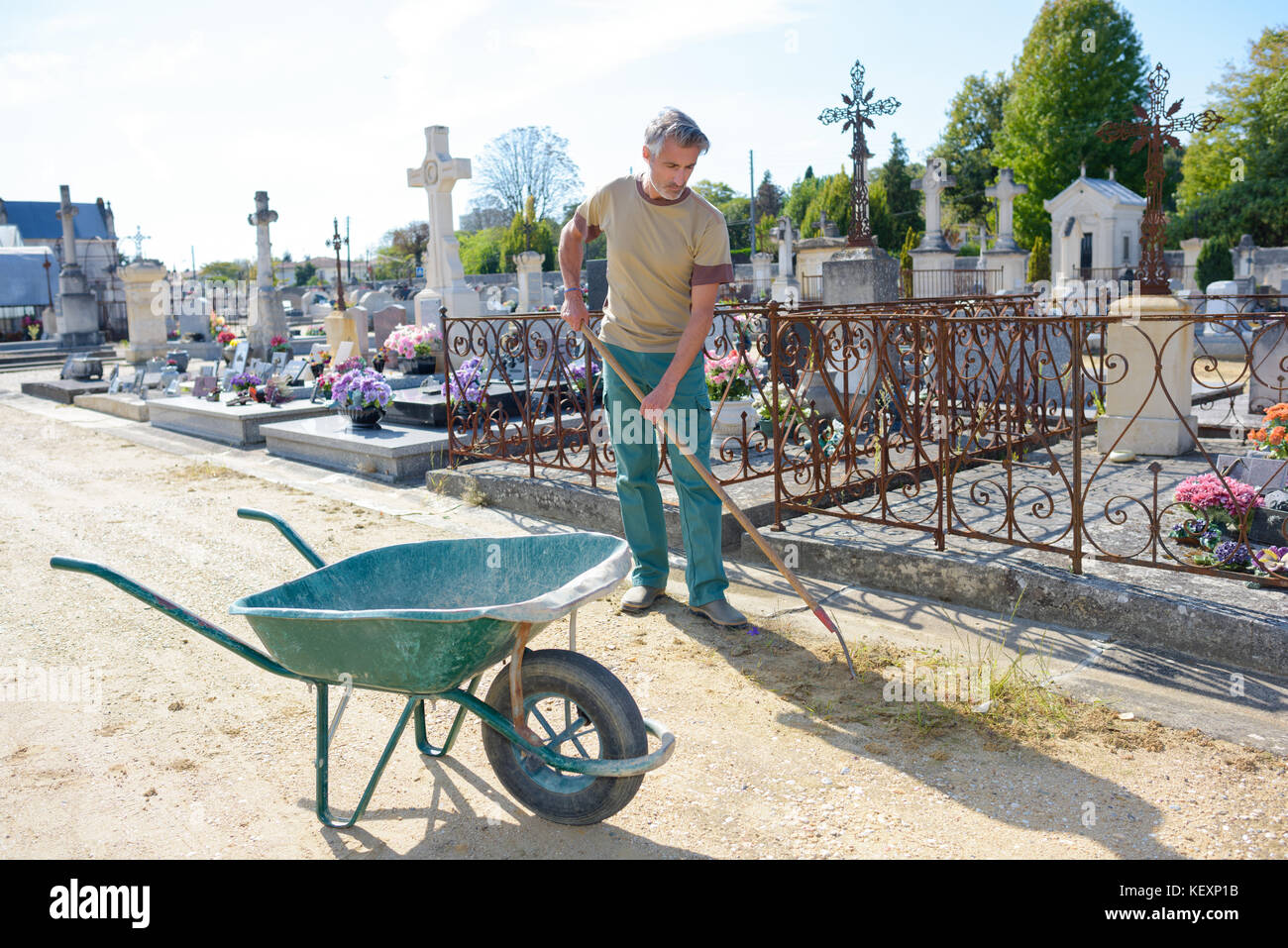 Maintenance man working in graveyard Stock Photo - Alamy