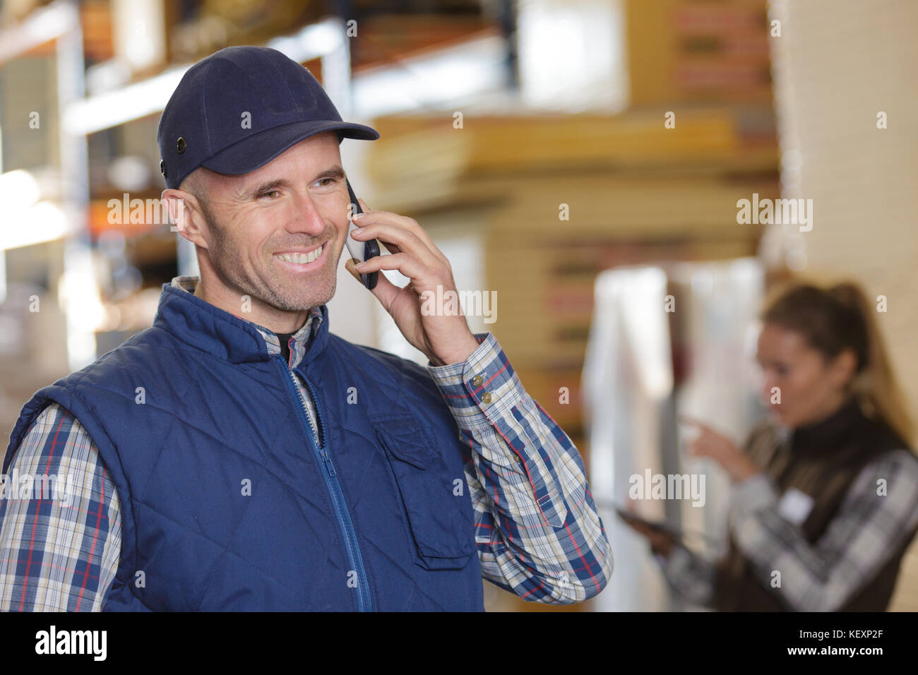 worker using mobile phone in warehouse Stock Photo - Alamy