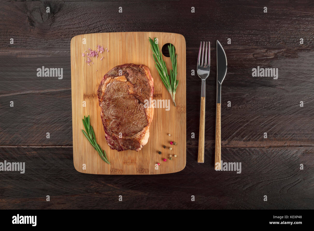 Cooked meat on rustic textures with seasoning and copyspace Stock Photo ...