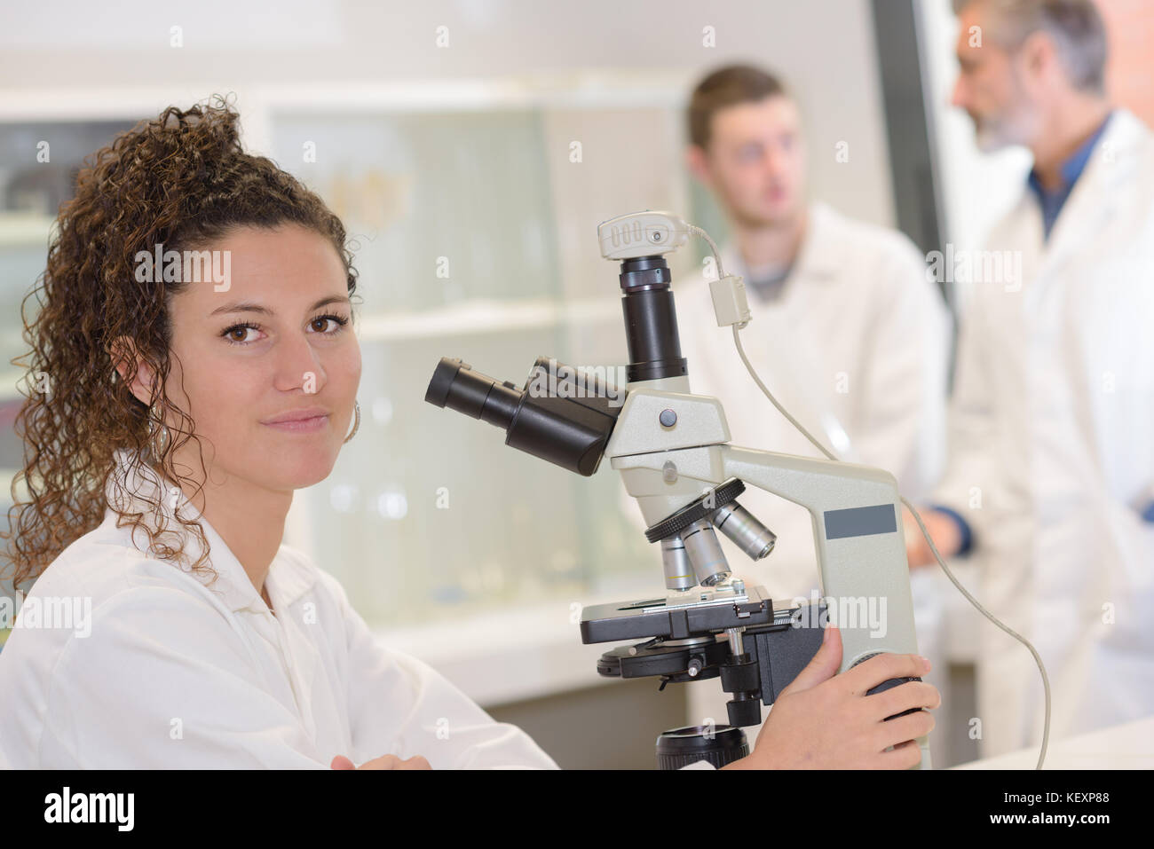 female scientist looking to microscope Stock Photo - Alamy