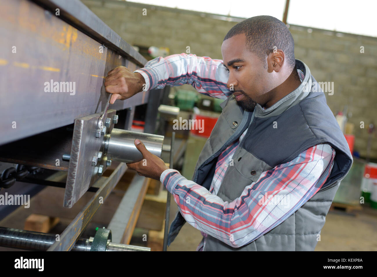 Man adjusting machine with spanner Stock Photo - Alamy