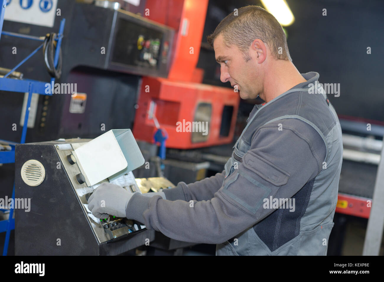 Worker setting up factory equipment Stock Photo - Alamy