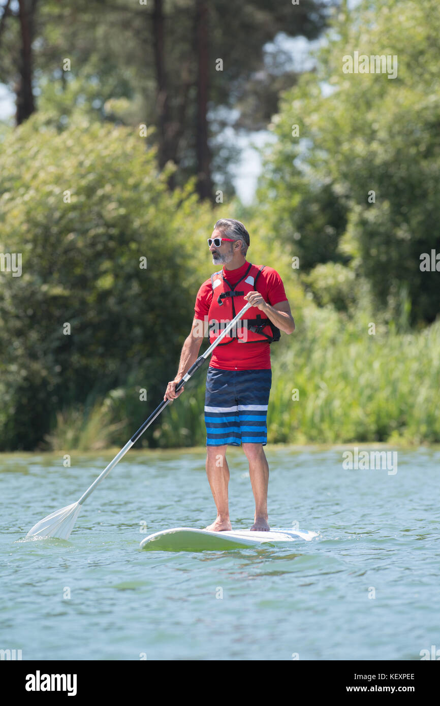 man enjoying a ride on the lake with paddleboard Stock Photo - Alamy