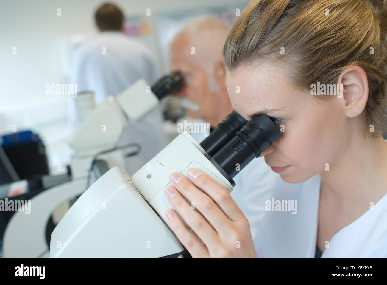 Laboratory worker looking into microscope eyepiece Stock Photo - Alamy