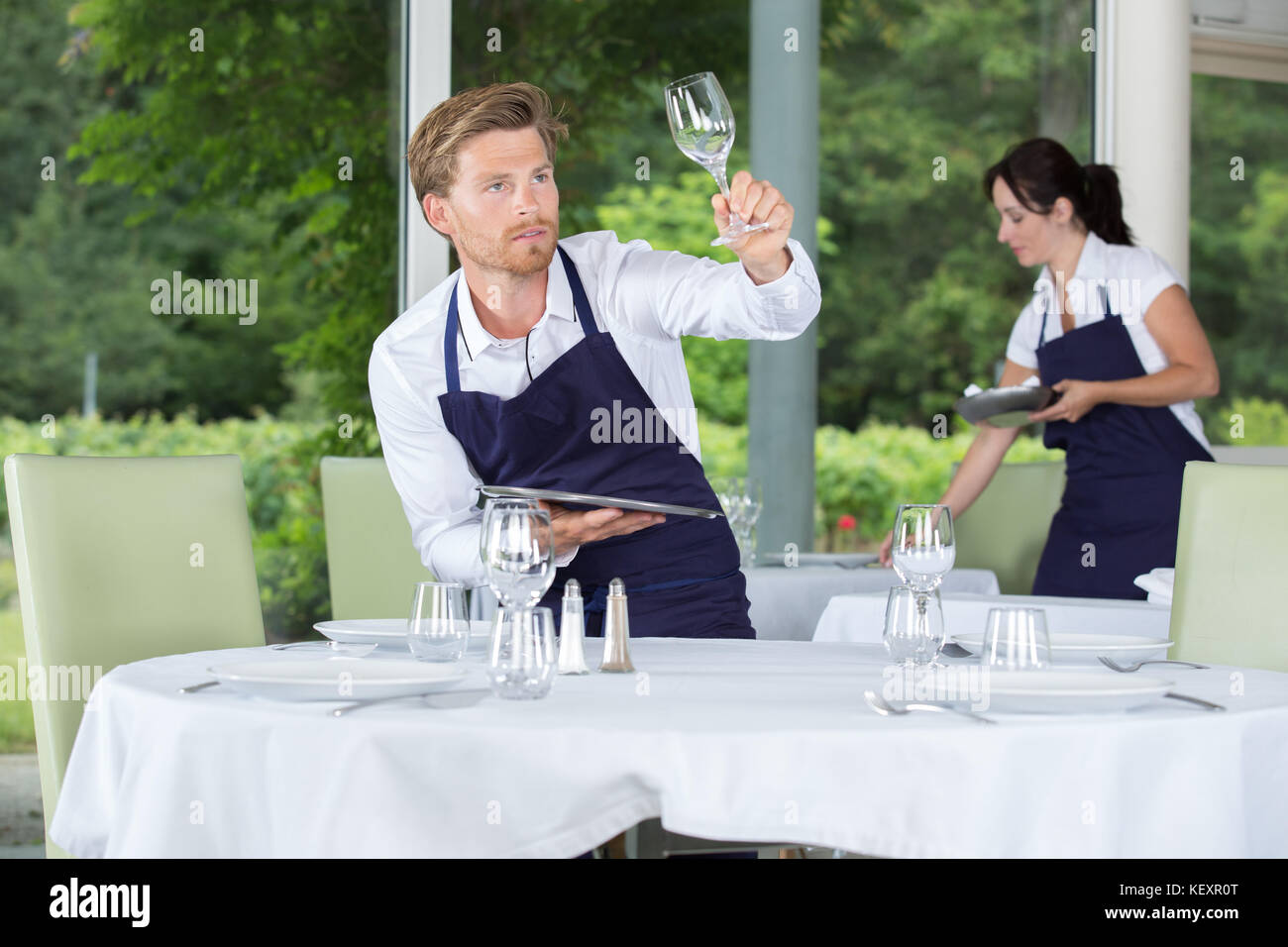 Waiter checking glassware is clean Stock Photo - Alamy