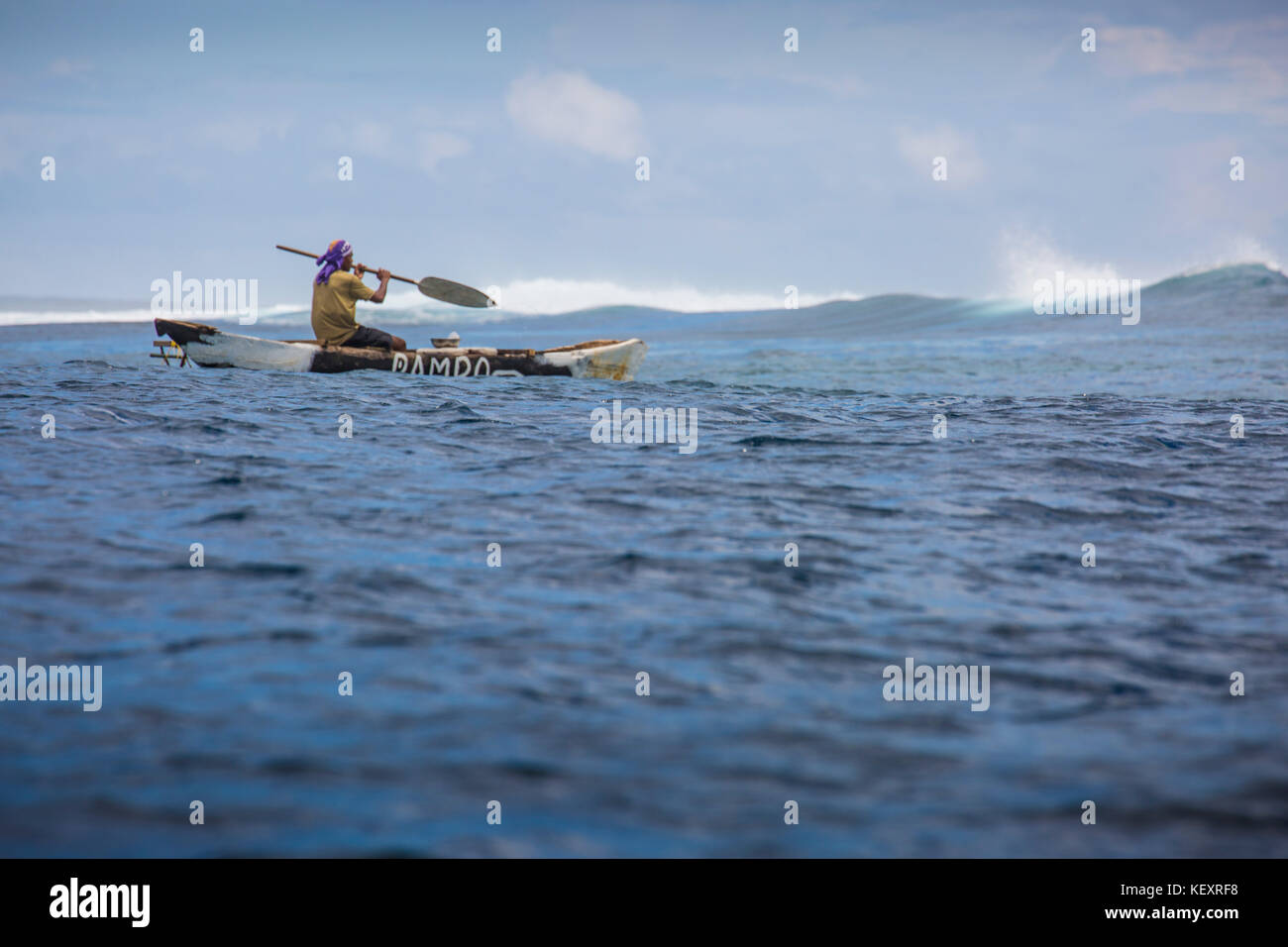 Photograph of local Samoan fisherman paddling in outrigger canoe, Samoa ...