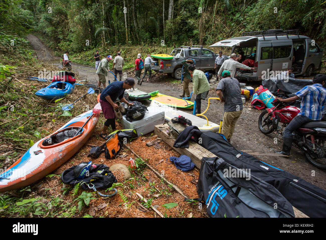 Photograph of men assembling stand-up paddleboard and kayak gear in ...