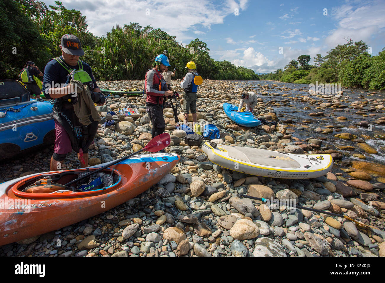 Photograph of men assembling stand-up paddleboard and kayak gear in ...