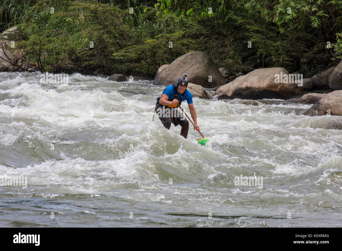 Man rides wave in jungle of Peru on stand-up paddleboard (SUP) while on ...