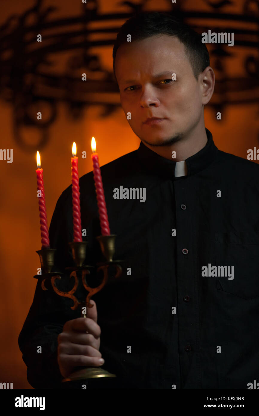 Portrait of handsome catholic priest or pastor with dog collar, dark ...