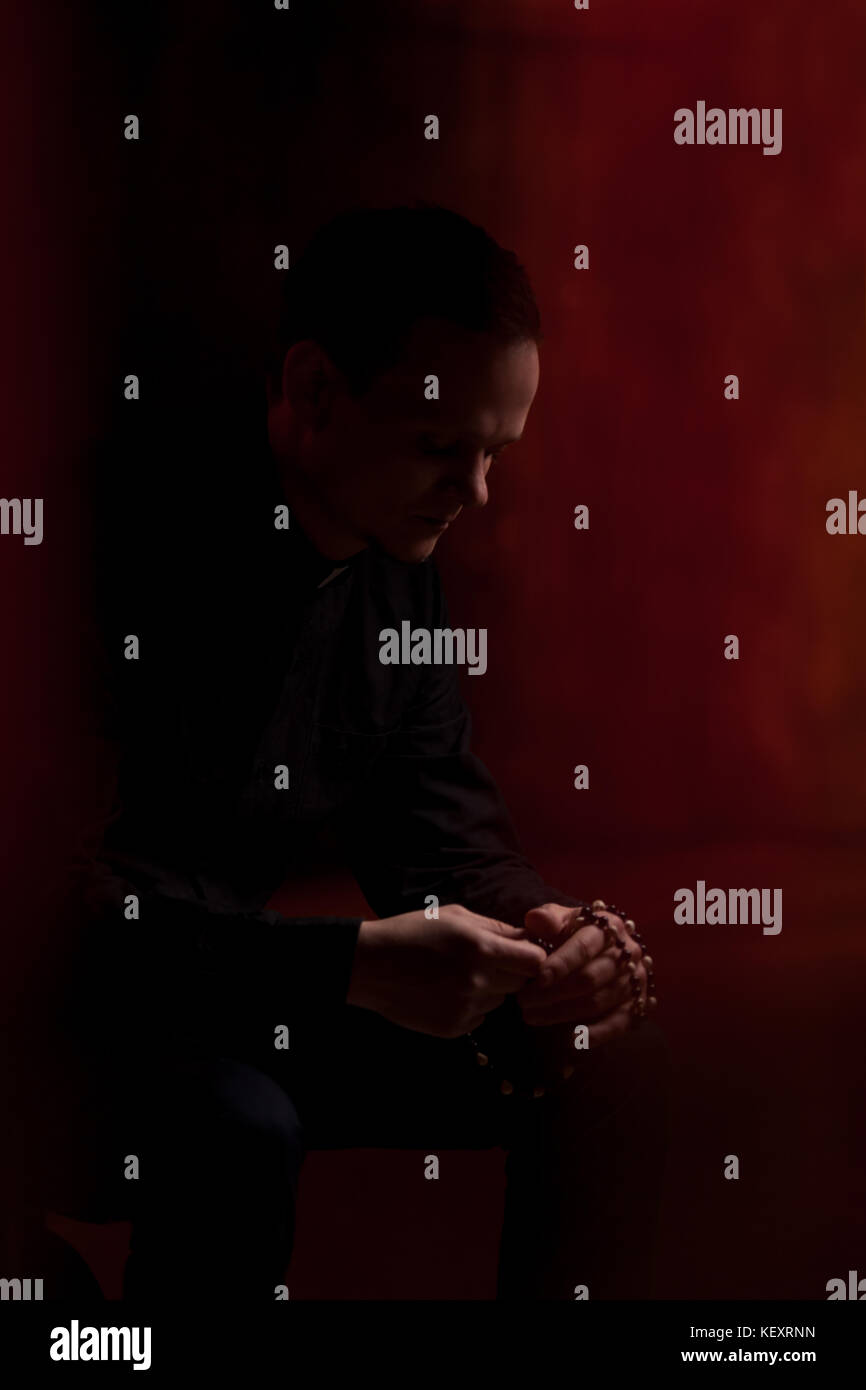 Portrait of handsome catholic priest or pastor with dog collar, dark ...