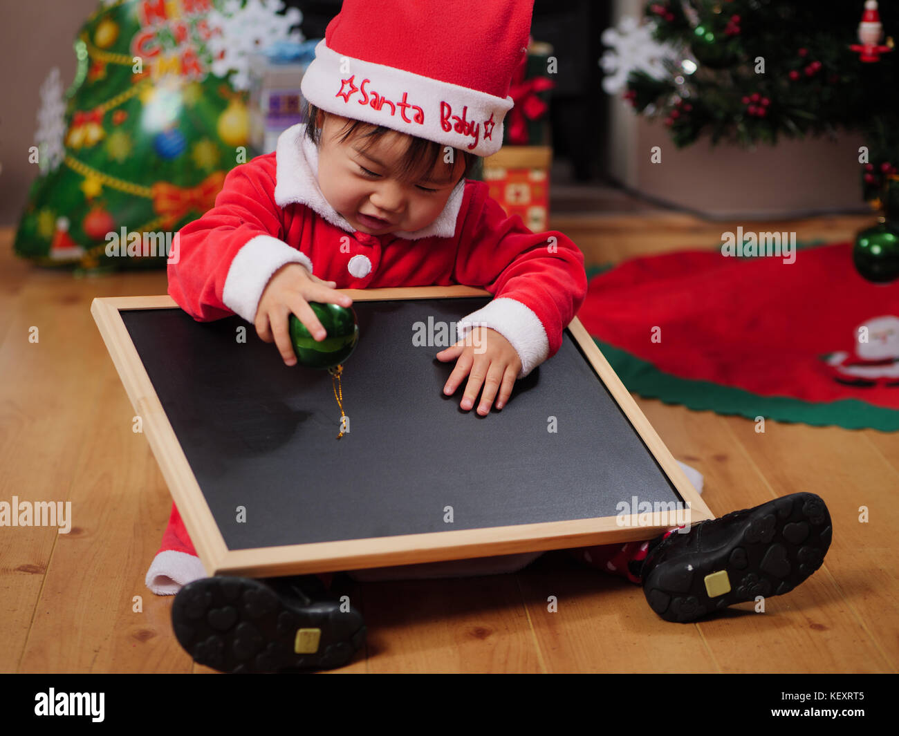 Happy santa baby girl hold a blank black board Stock Photo - Alamy