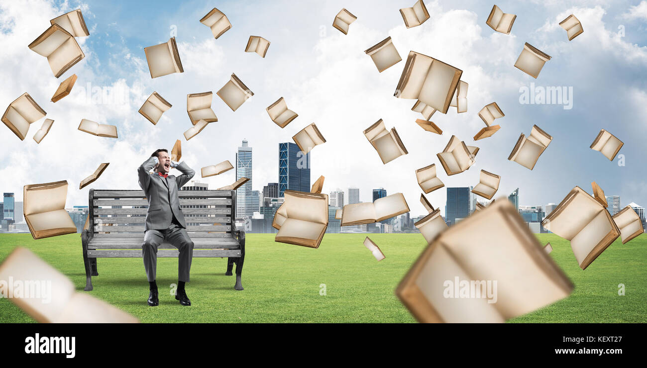 Many old books falling from above and student guy sitting on bench ...