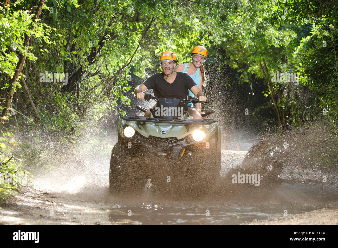 Couple driving quad bike through large puddle in Emotions Native Park ...