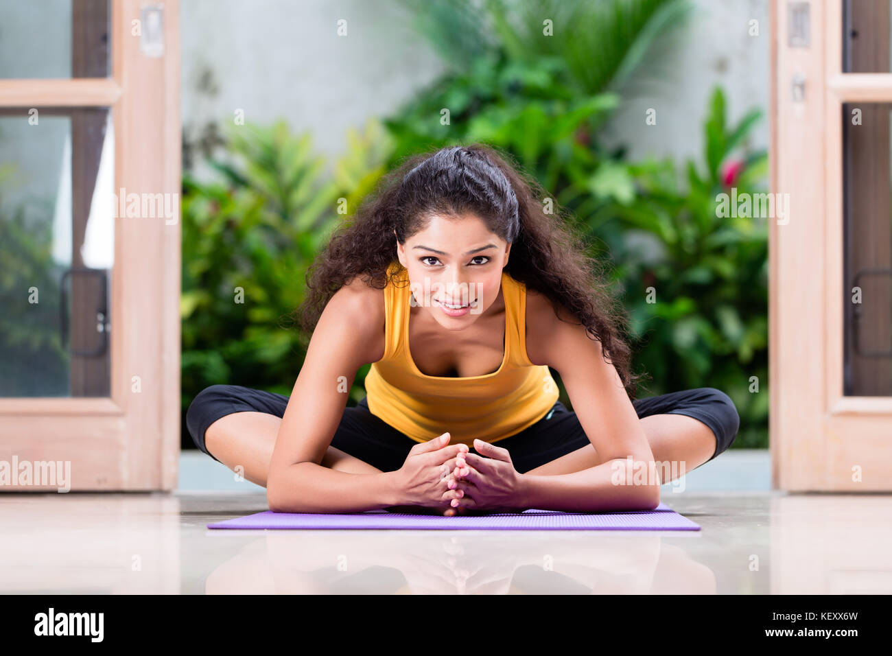 Young woman doing stretching exercise indoors Stock Photo - Alamy