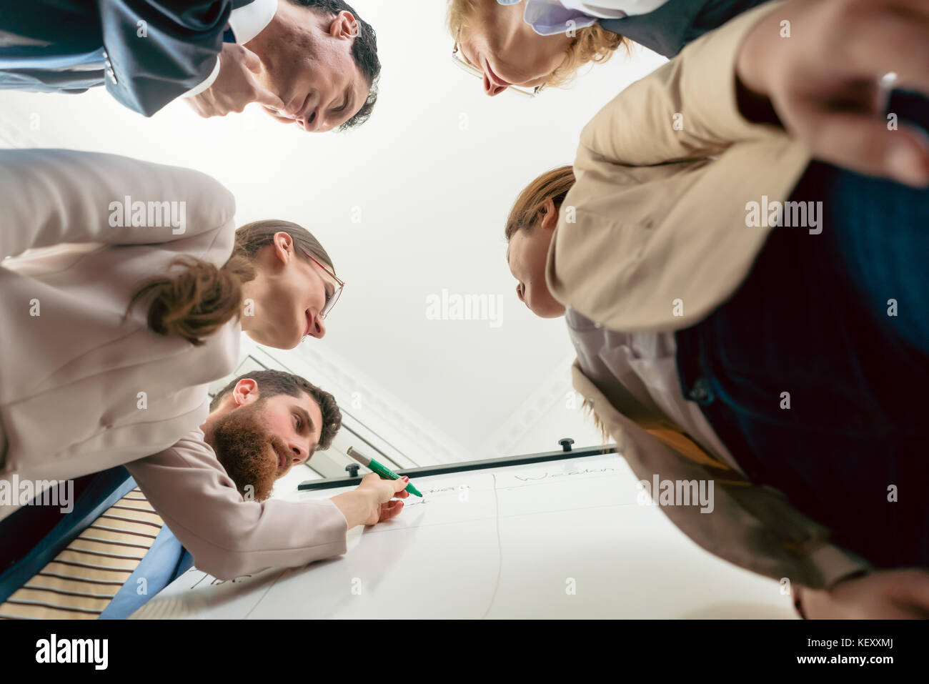 Low-angle view of an international team working together during Stock ...