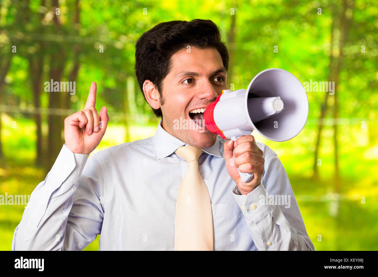 Portrait of a smiling handsome man talking with a megaphone in a ...