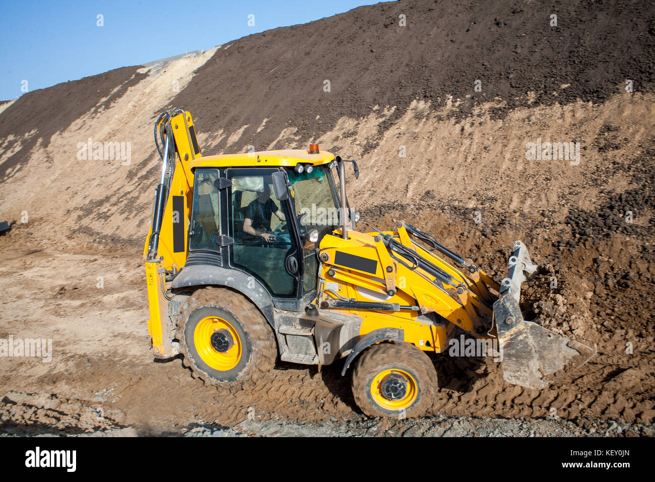 Tractor loader backhoe digger loader on a construction site with blue ...