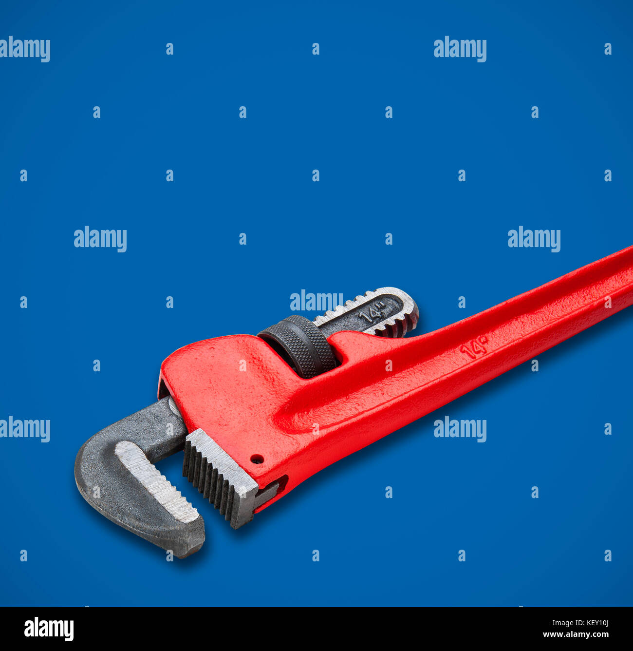 Red Pipe wrench on blue background Stock Photo - Alamy