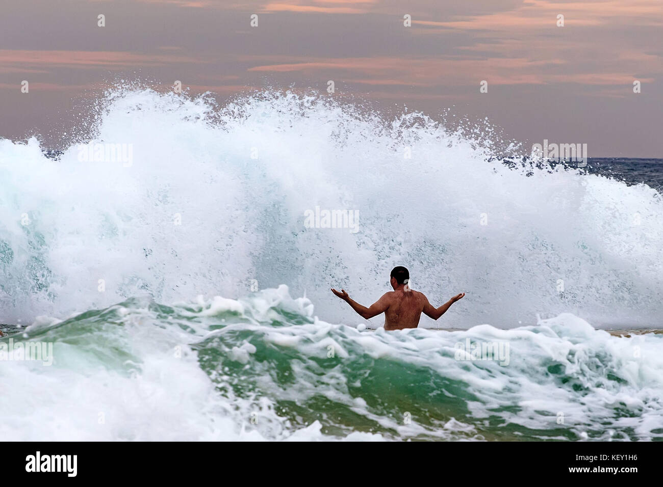Man swims in the surf during a storm Stock Photo - Alamy