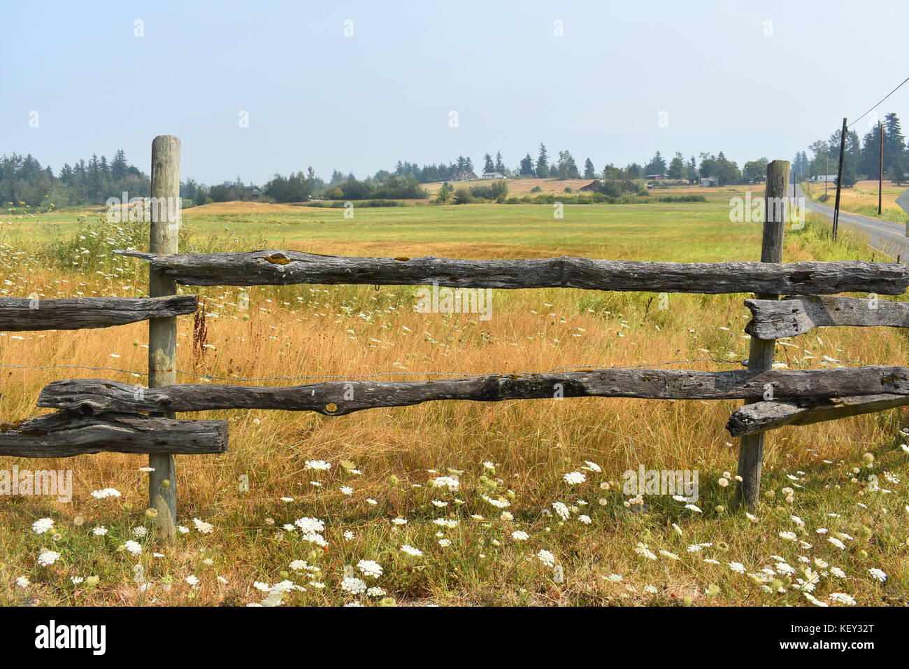An old worn fence with barns and houses in the distance Stock Photo - Alamy