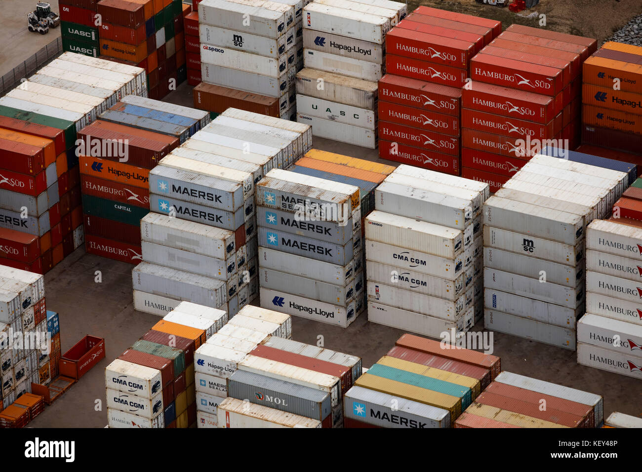 A close up aerial view of shipping containers stacked up in a yard ...