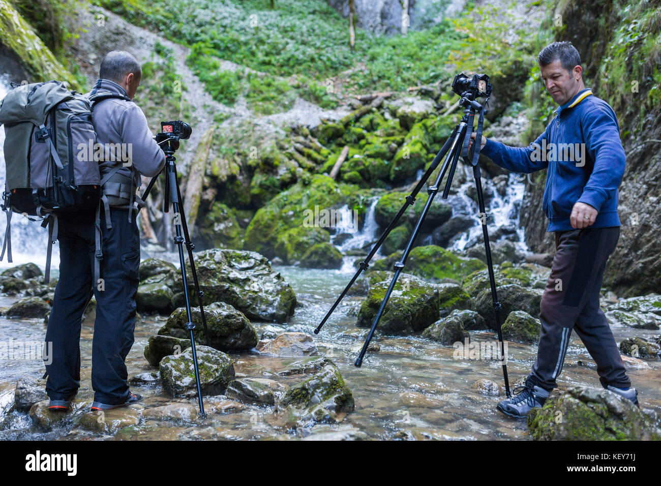 Professional photographers with cameras on tripod shooting in a river ...