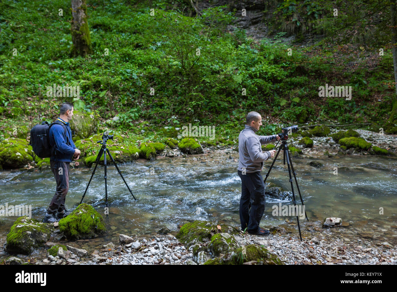 Professional photographers with cameras on tripod shooting in a river ...