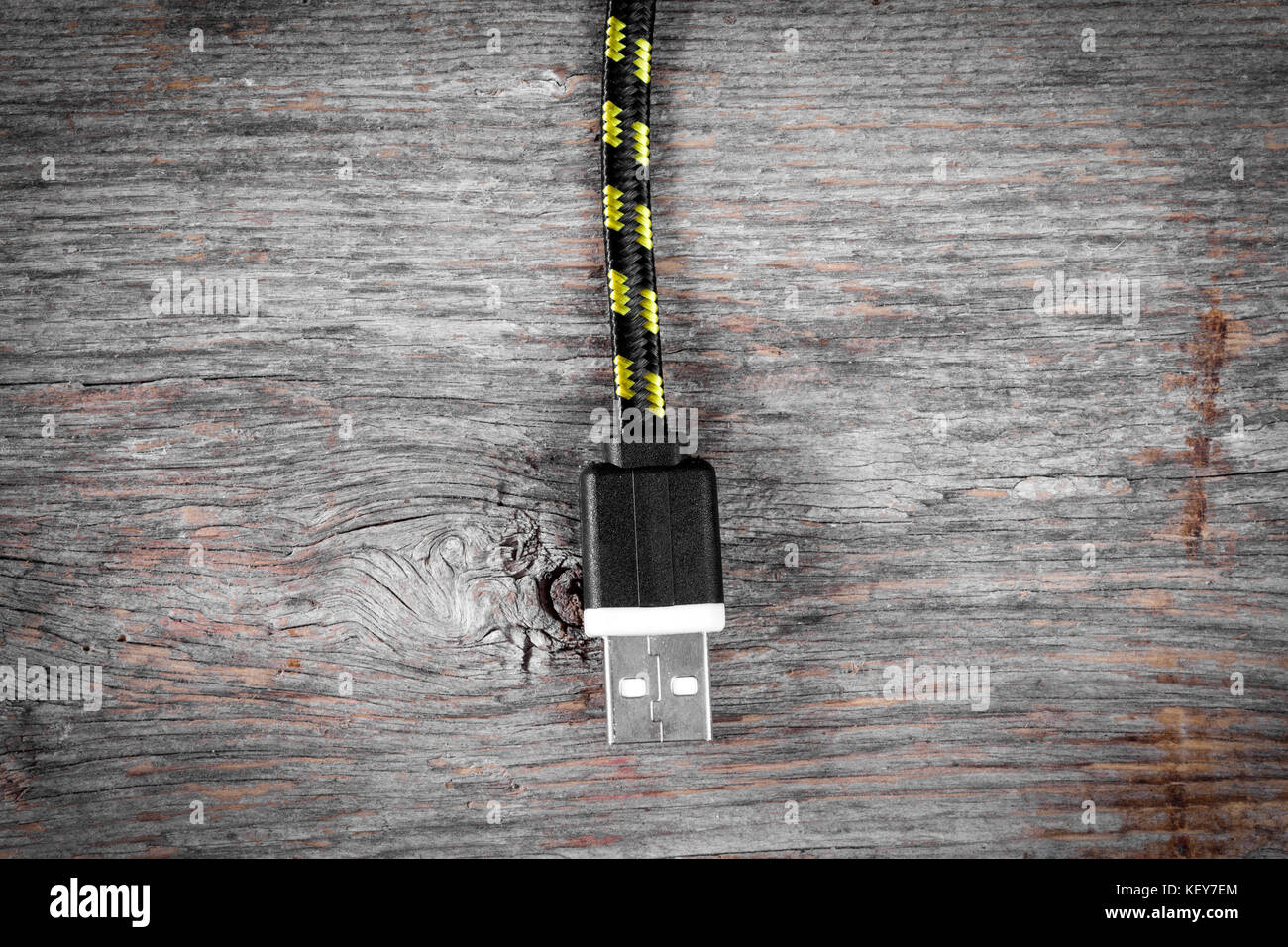 Nylon braided USB cable hanging over wooden background Stock Photo - Alamy
