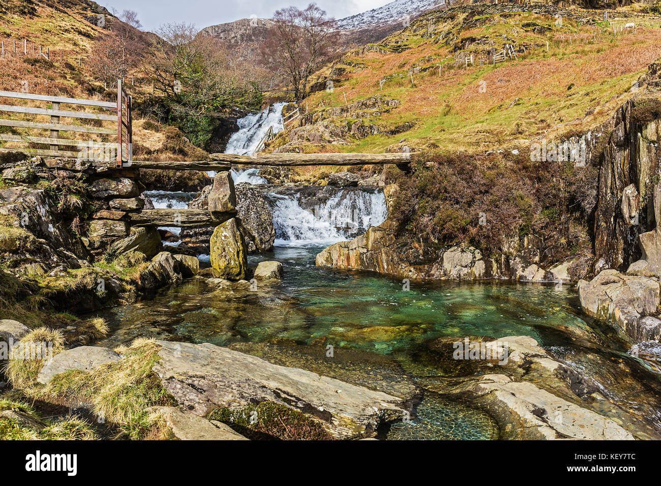 Slate stone bridge over Afon (River) Cwm Llan showing turquoise pool ...