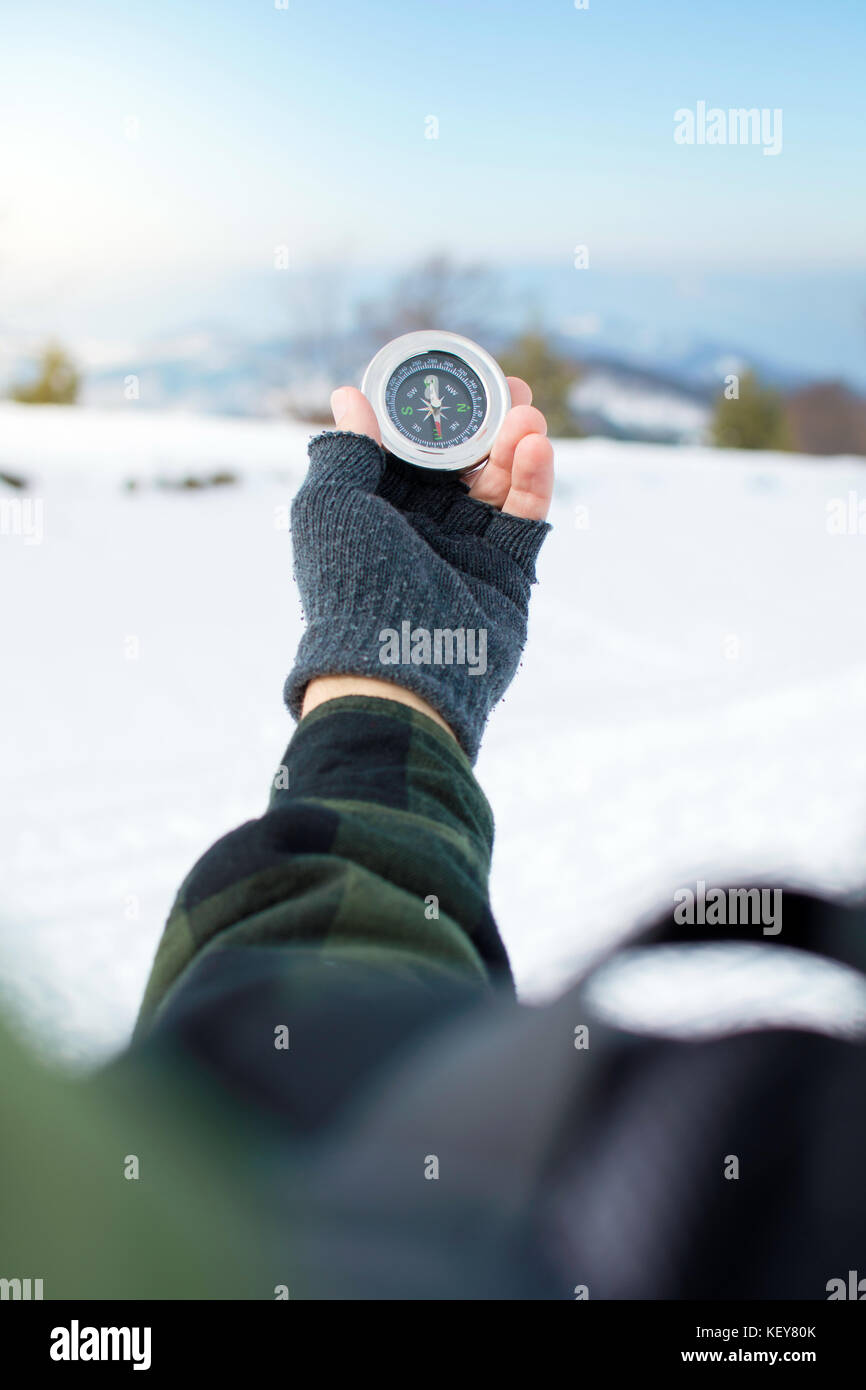 Man holding a metal compass on snowy mountain Stock Photo - Alamy