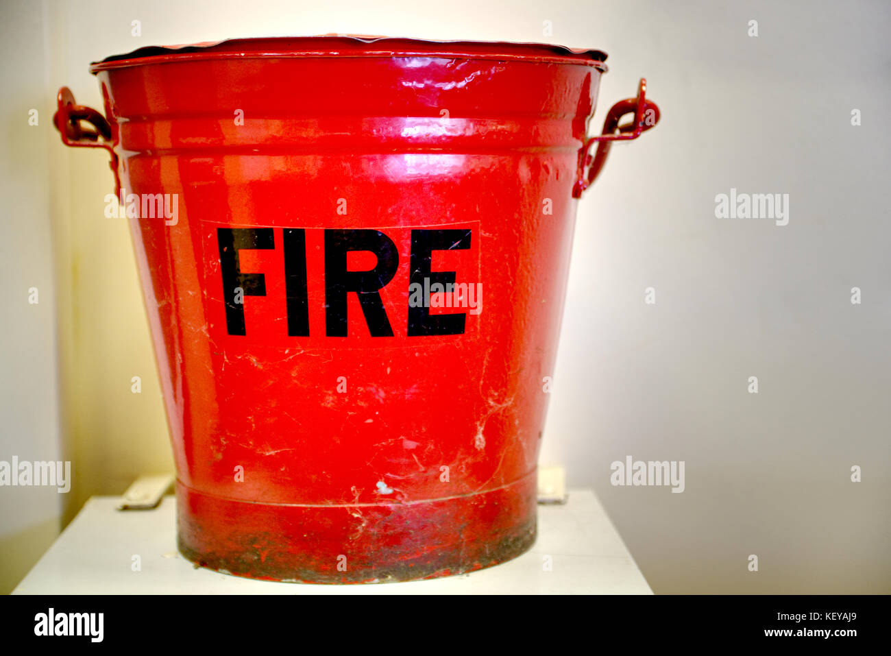 Red fire safety bucket on left hand side of the image Stock Photo - Alamy