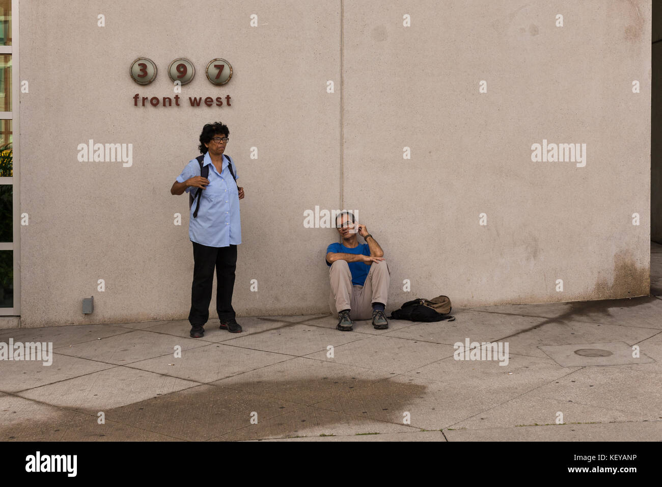 a minimalist photo of people waiting in front of a bulding in dowtown ...