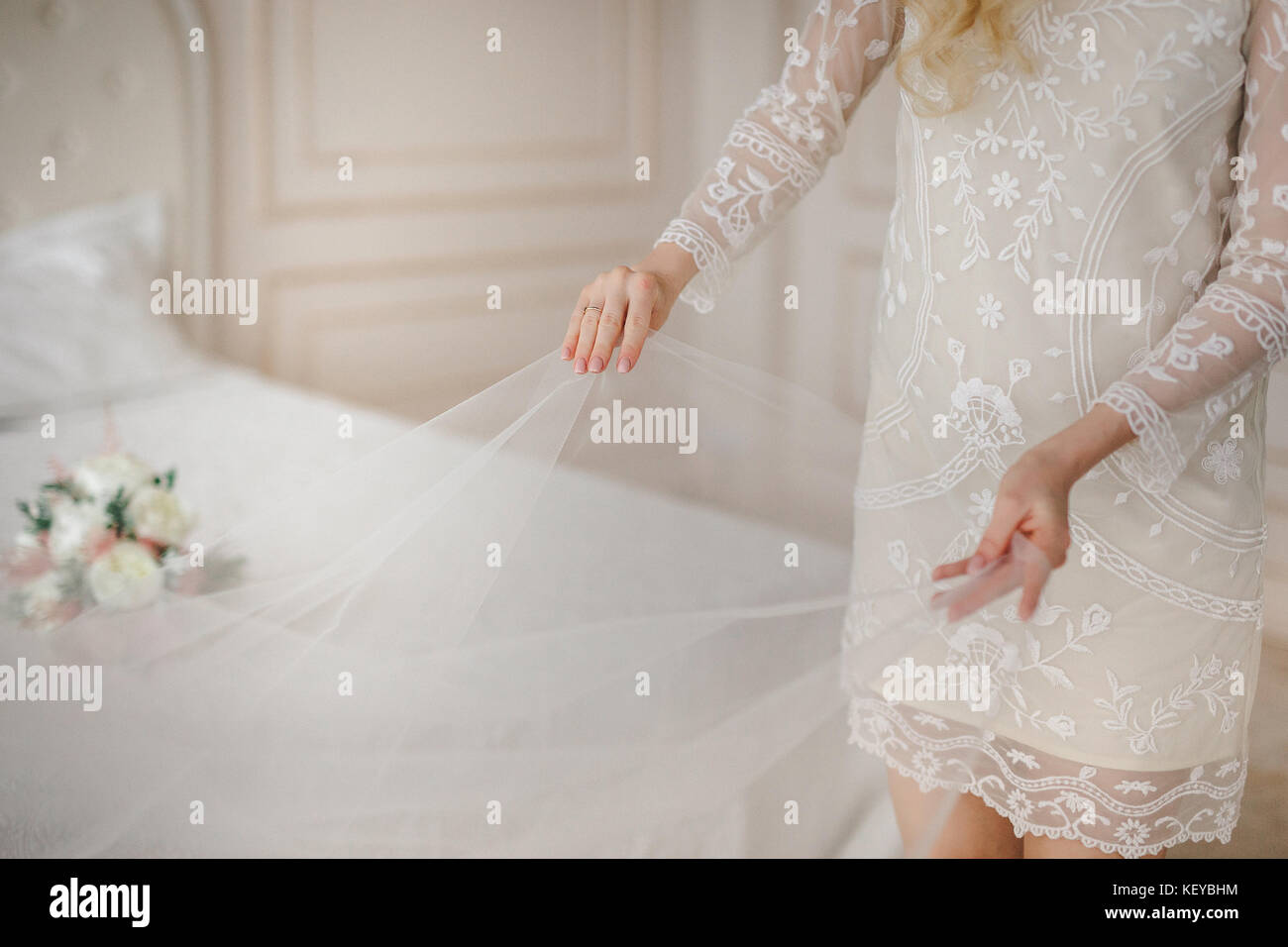 Bridesmaid preparing bride for the wedding day, helping fasten her ...