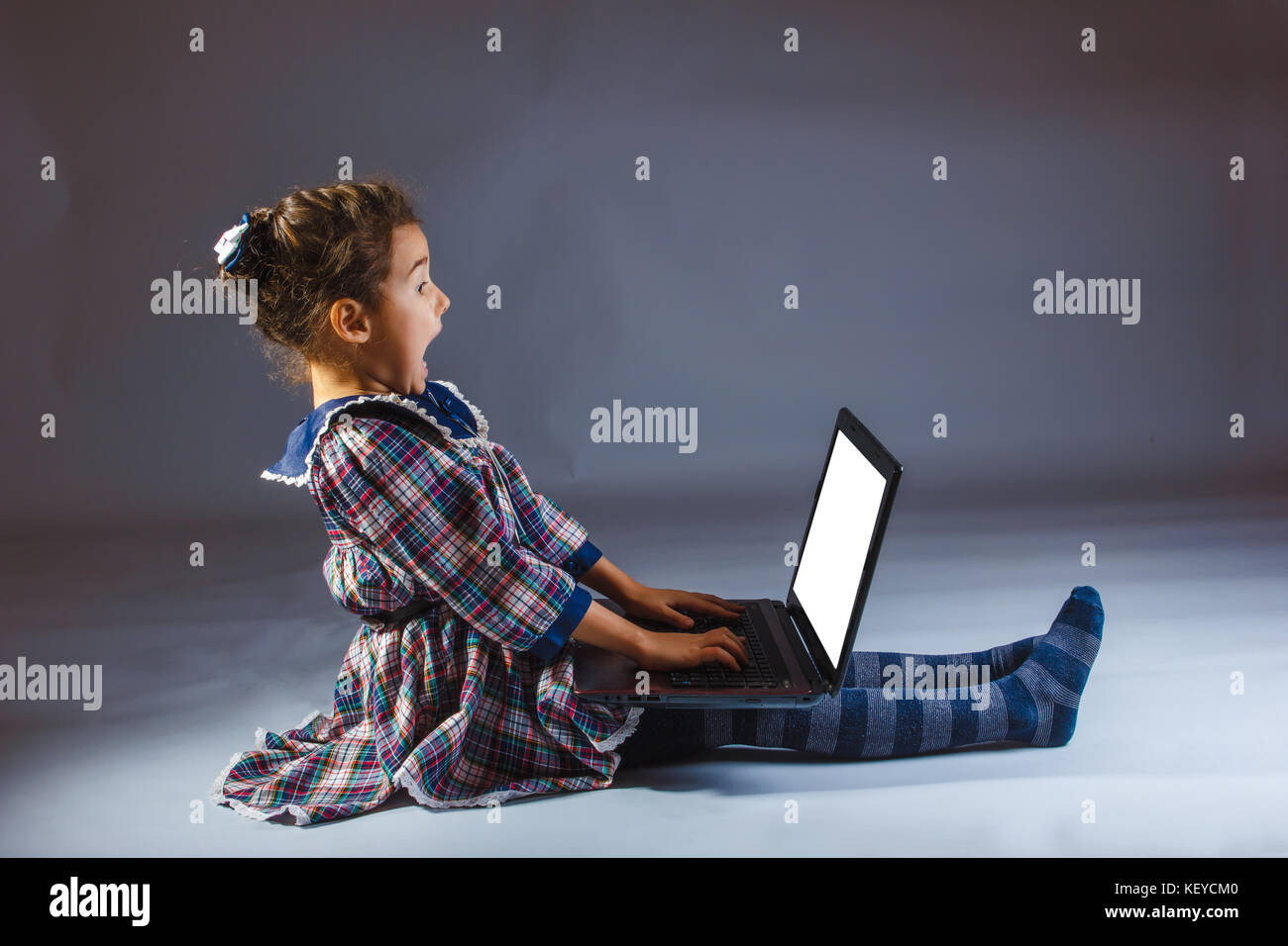 girl looking computer on a gray background surprise Stock Photo - Alamy