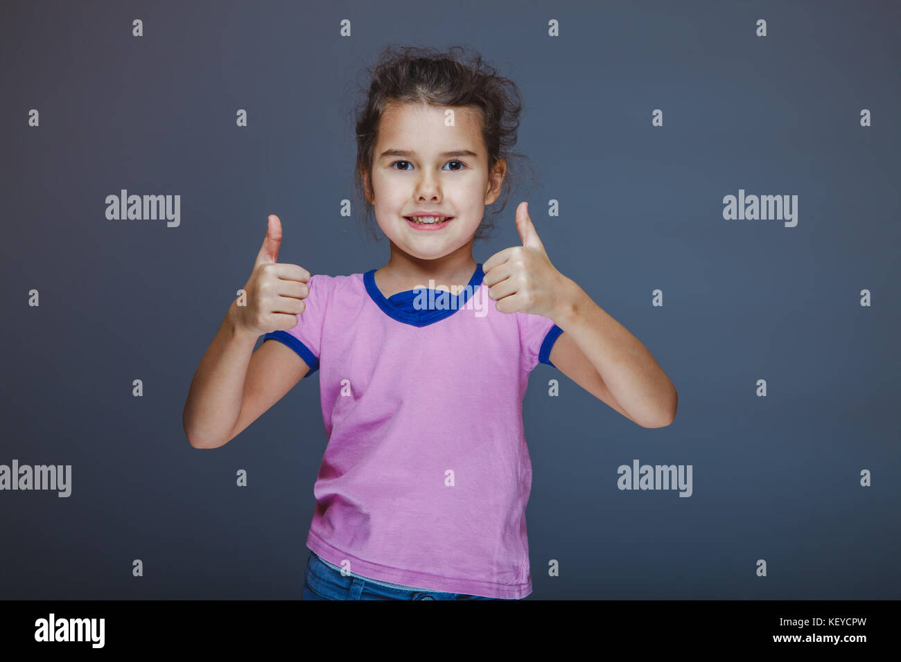 little girl shows sign 'yes' fingers on a gray background Stock Photo ...