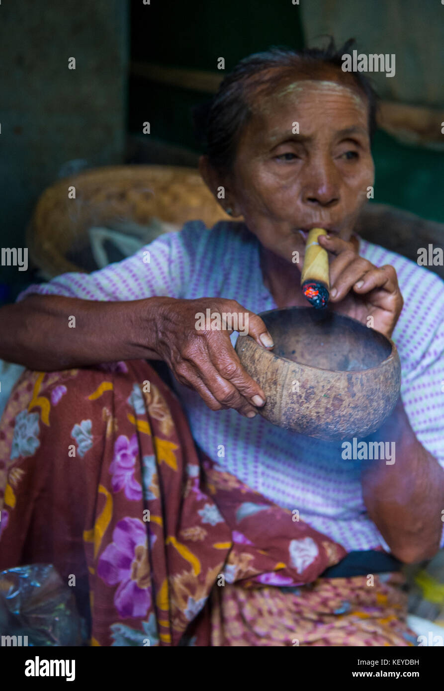 Woman smoking a cheroot cigar in market in bagan, Myanmar Stock Photo ...
